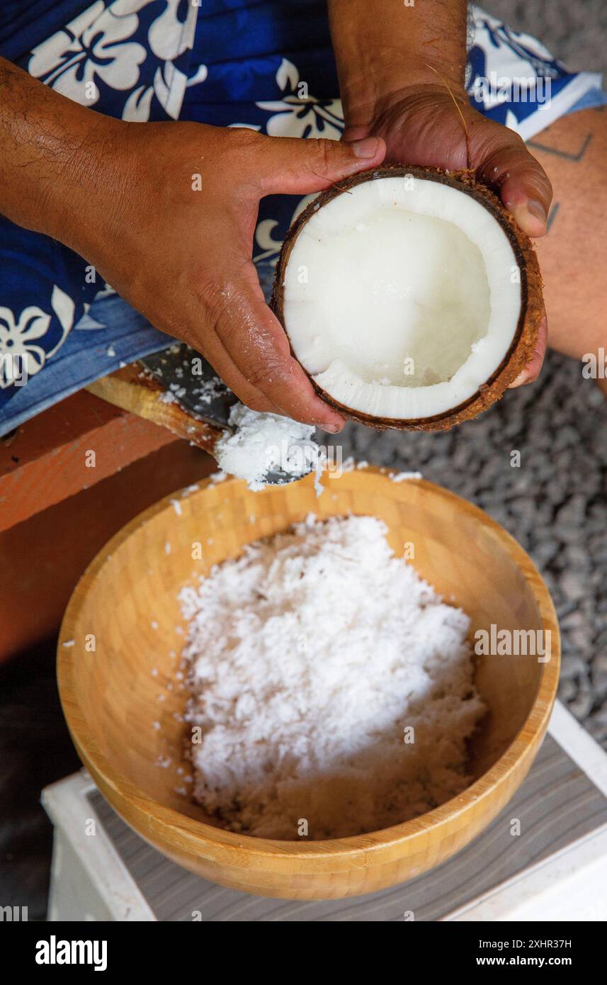 French Polynesia, Tahiti island, Polynesian grating a coconut in a ...