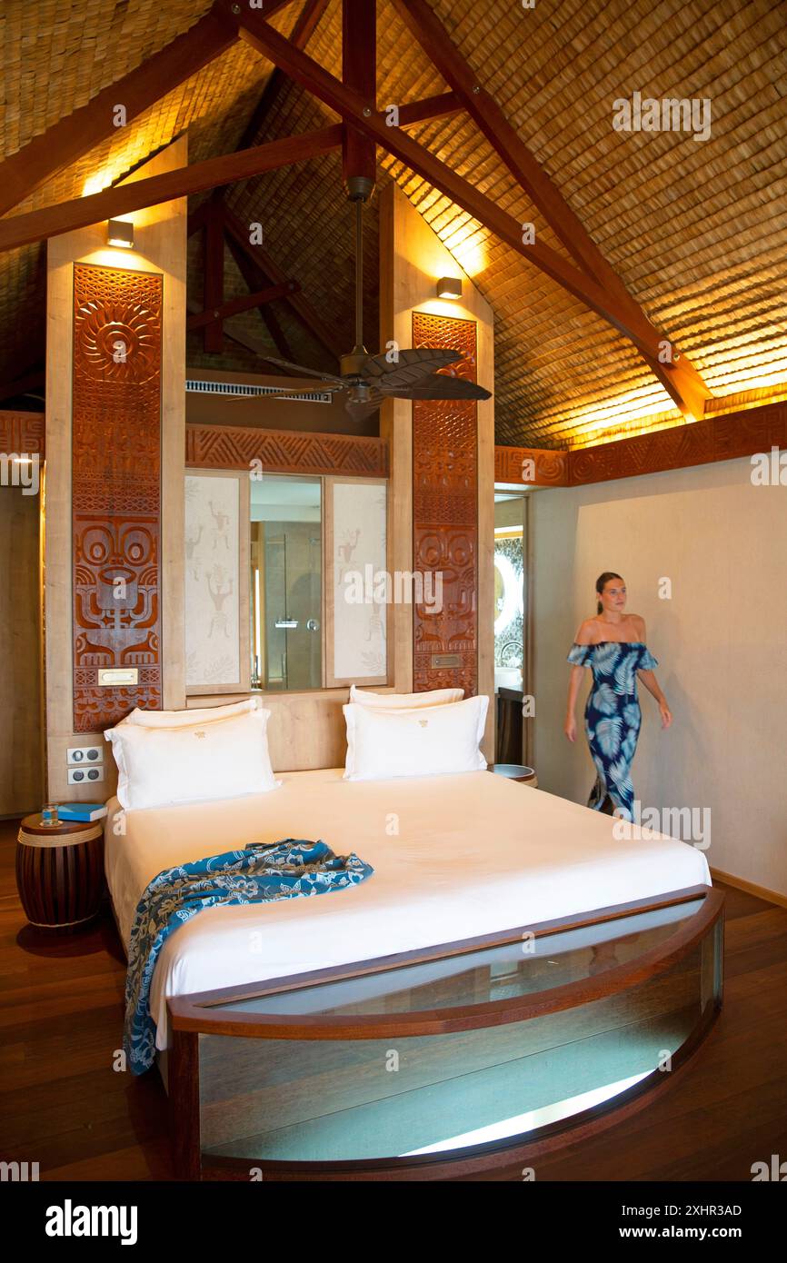 French Polynesia, Bora Bora island, woman in front of the bed decorated ...