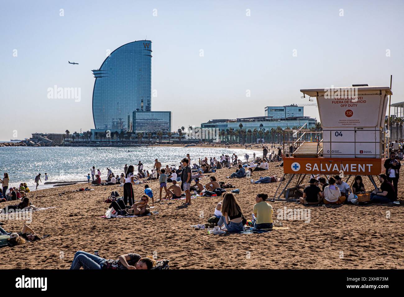 crowds of people filling the beach / sat on the beach in Barcelona ...