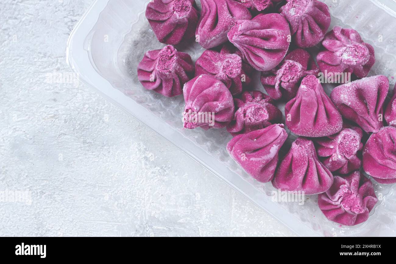 Freshly frozen beetroot khinkali, in a container, top view, no people ...