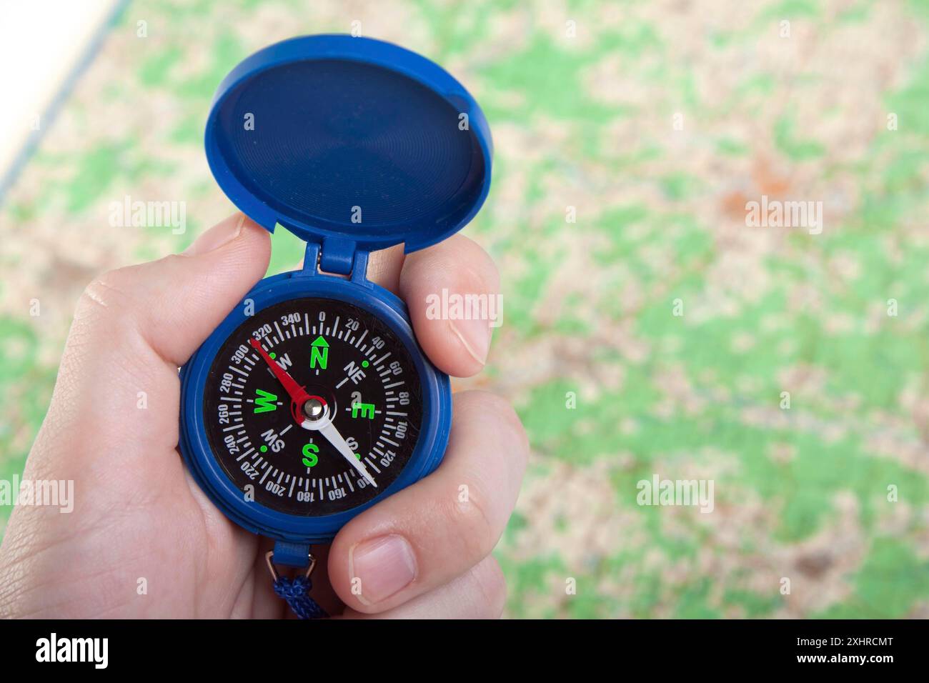 Hand holding travel north direction compass on map Stock Photo - Alamy