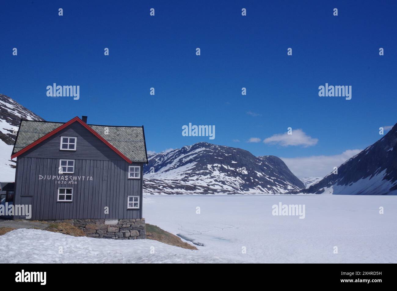 Mountain hut in a snow-covered late winter landscape, surrounded by ...