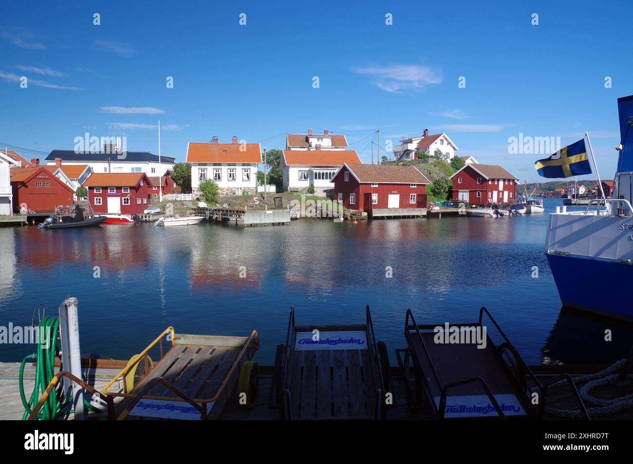 Scandinavian harbour town with red houses, blue sky and calm water ...