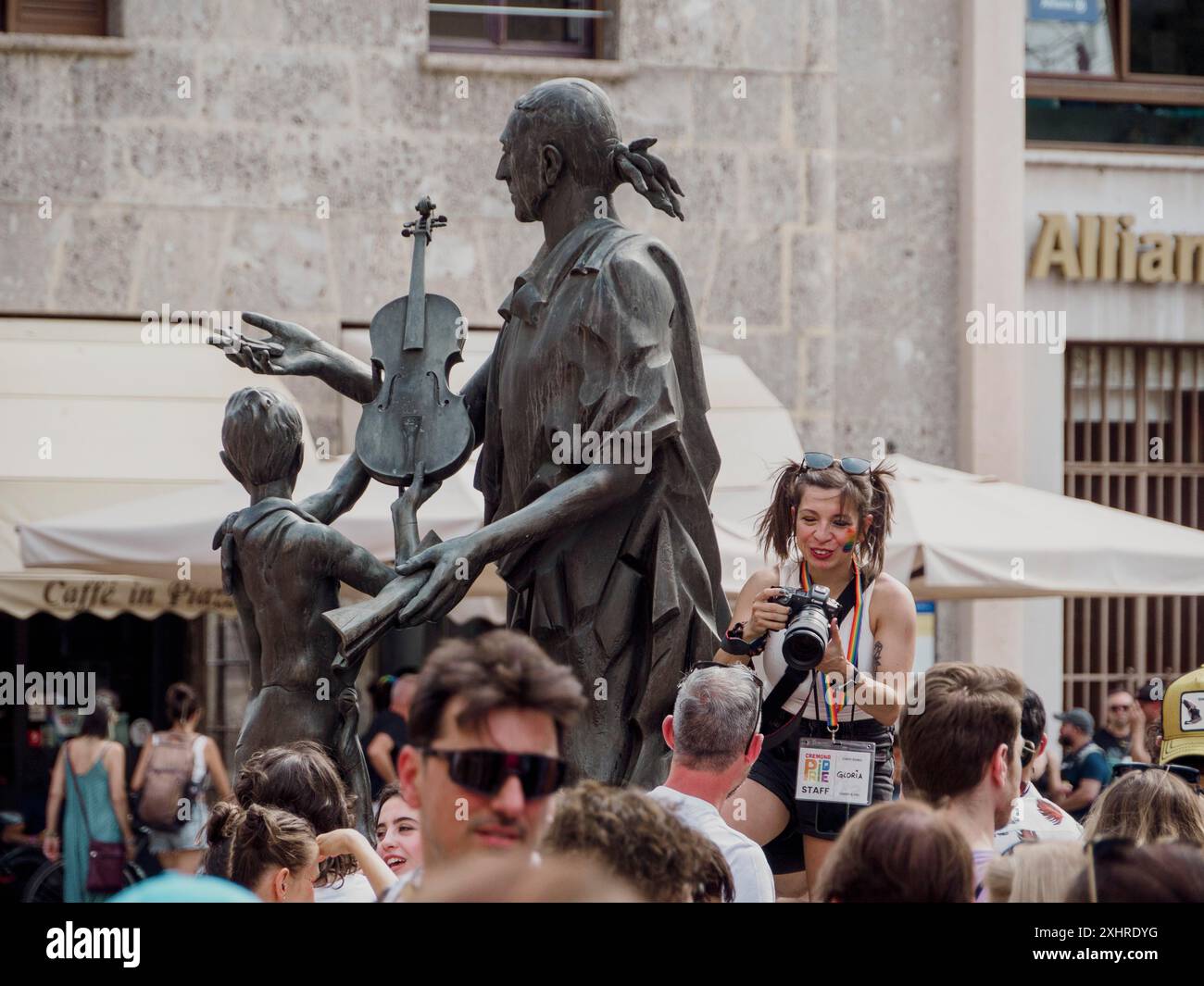 Statues in front of a crowd with a woman taking photographs during an ...