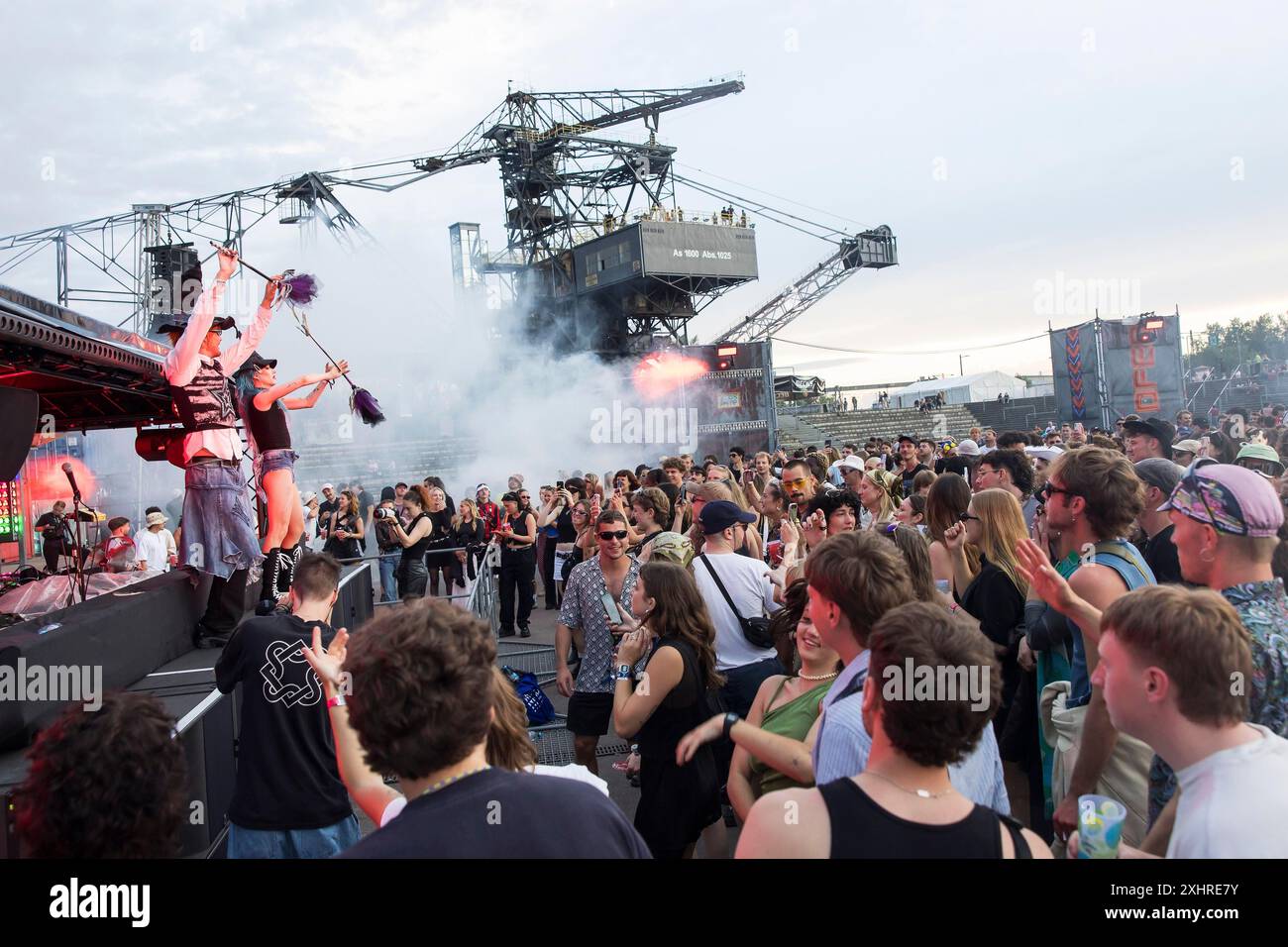 Celebrating visitors in front of excavators at the Melt Festival in ...