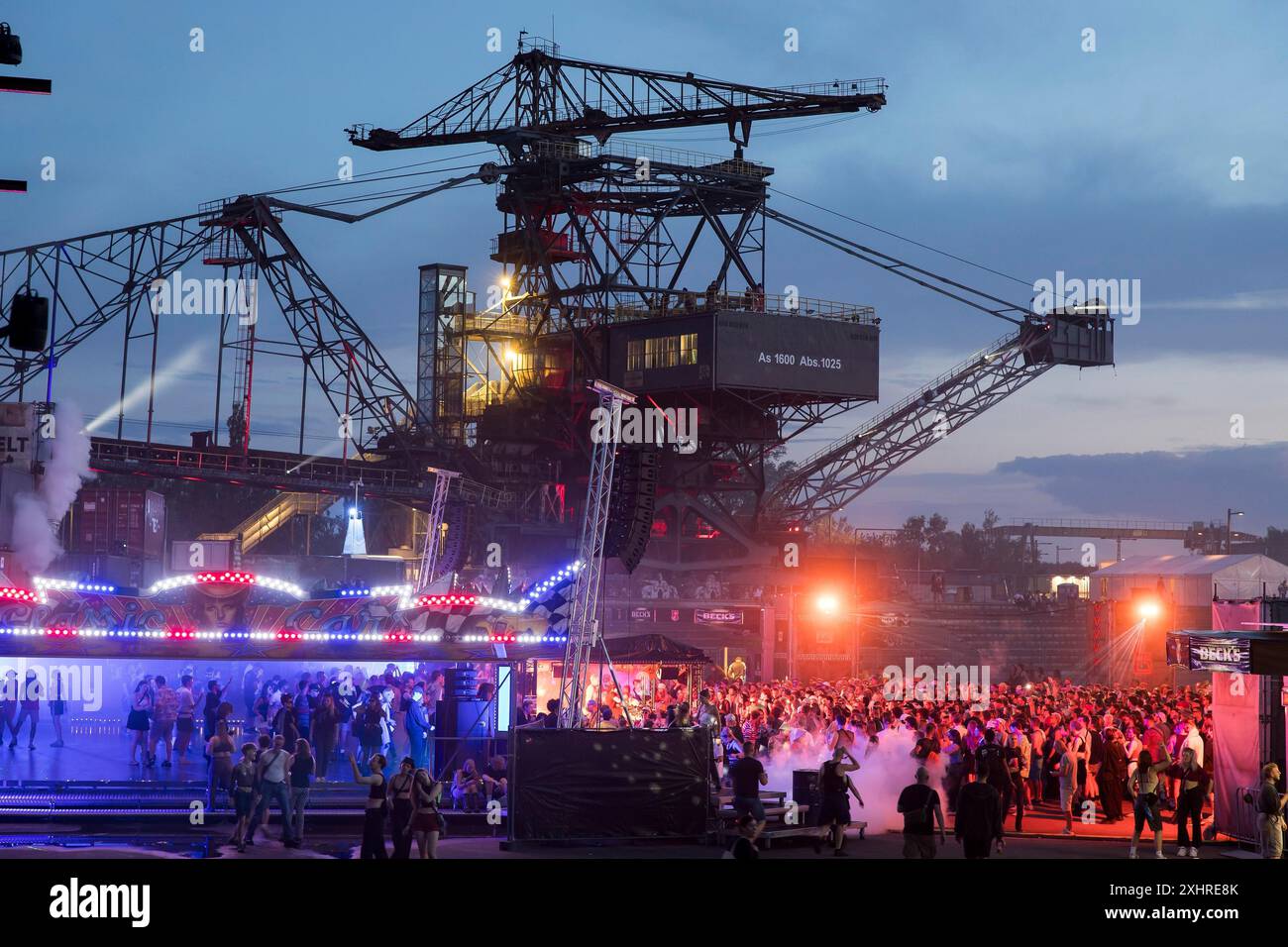 Festival visitors celebrate between excavators at the Melt Festival in ...