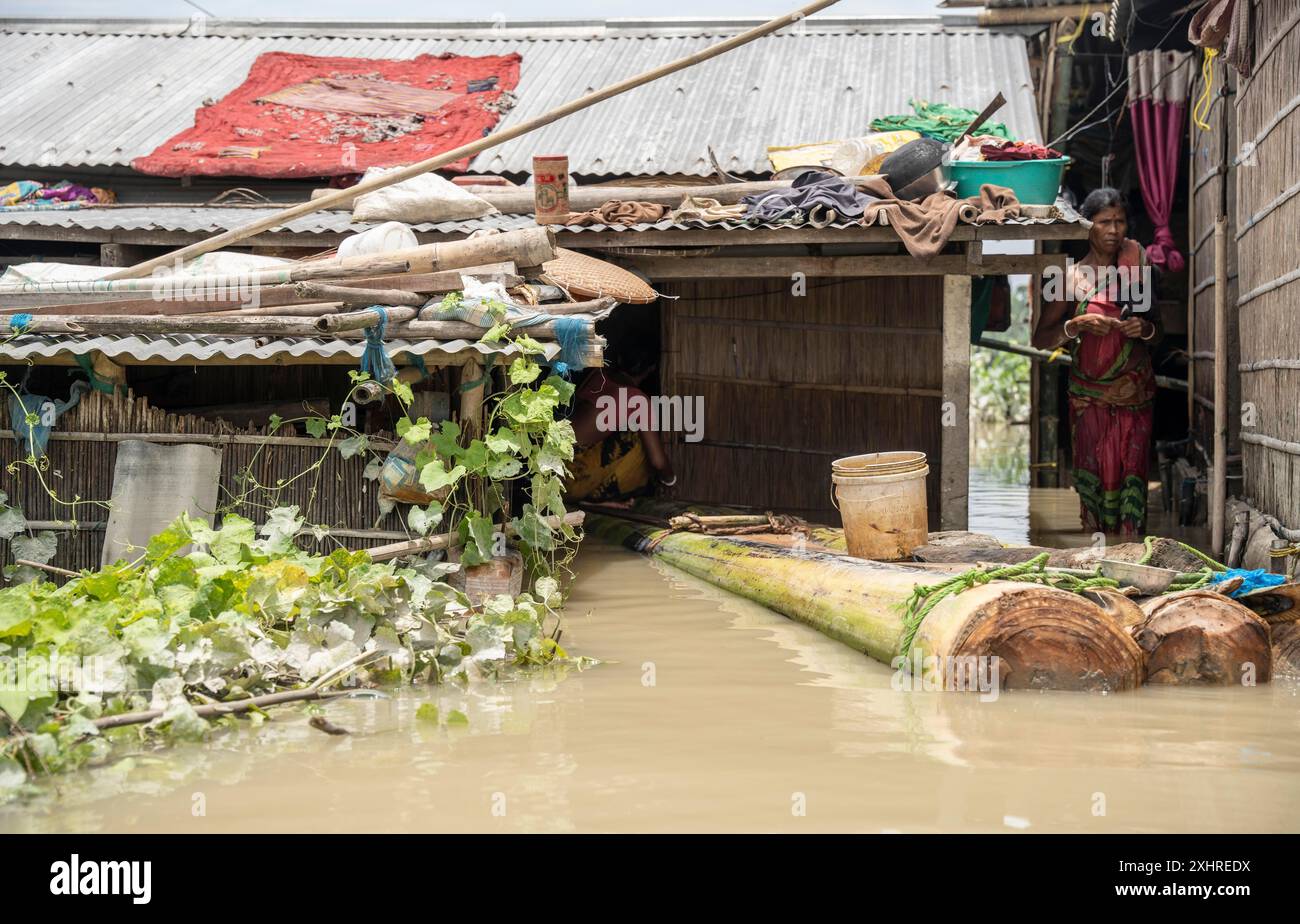 Morigaon, India. 4 July 2024. Residents in their flooded house, in a ...