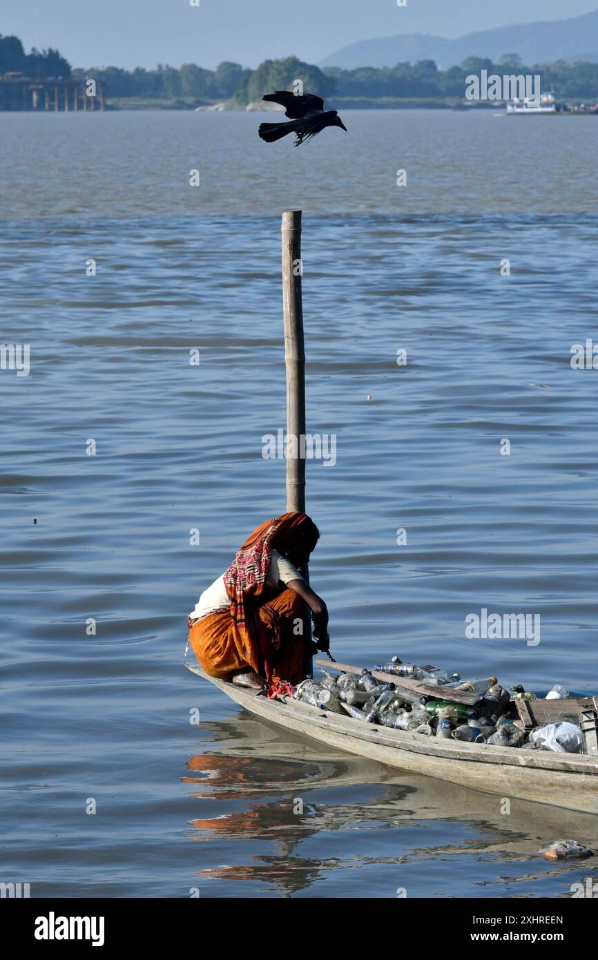 Rag picker collecting plastic bottle and other plastic materials in a ...