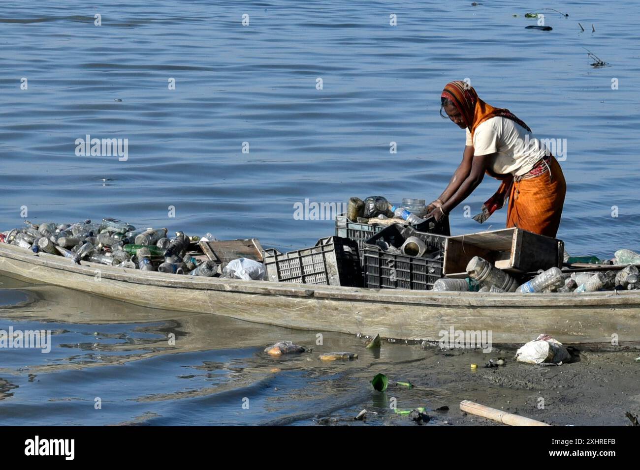 A women rag picker collecting plastic bottle and other plastic ...