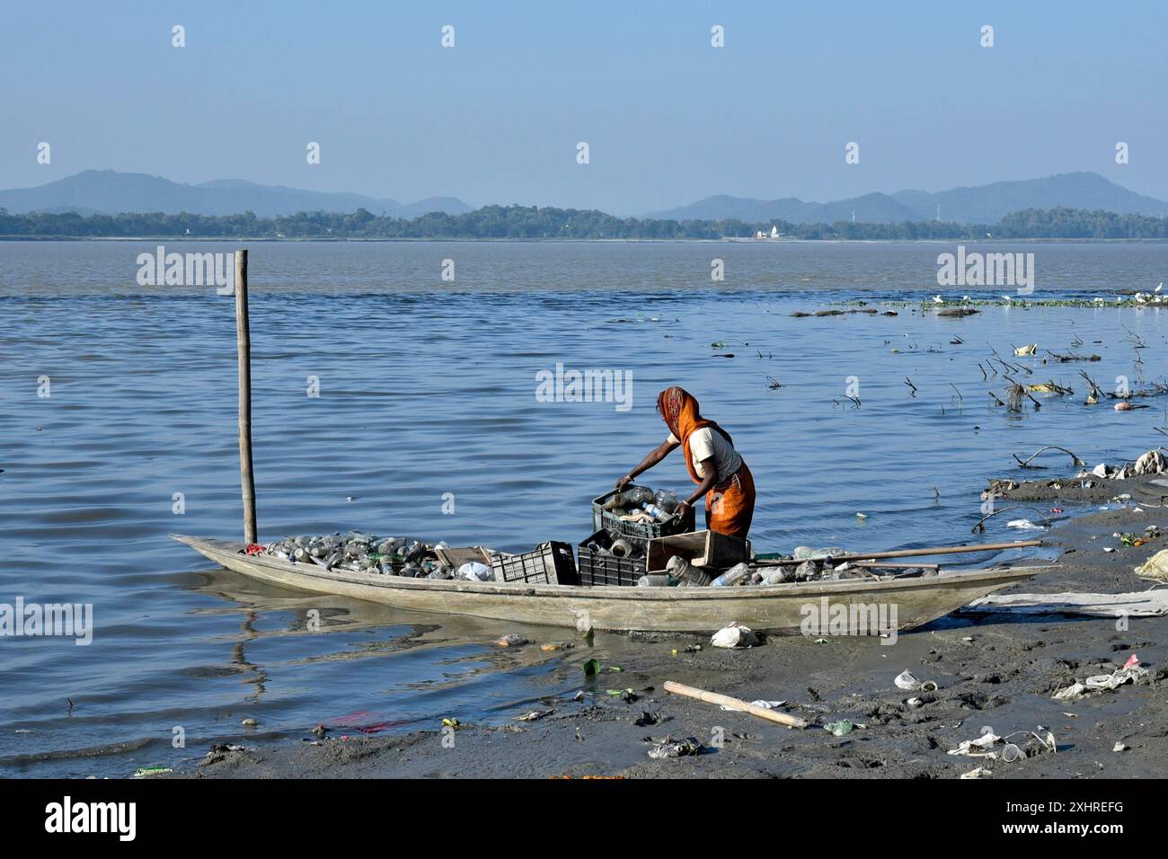A women rag picker collecting plastic bottle and other plastic ...