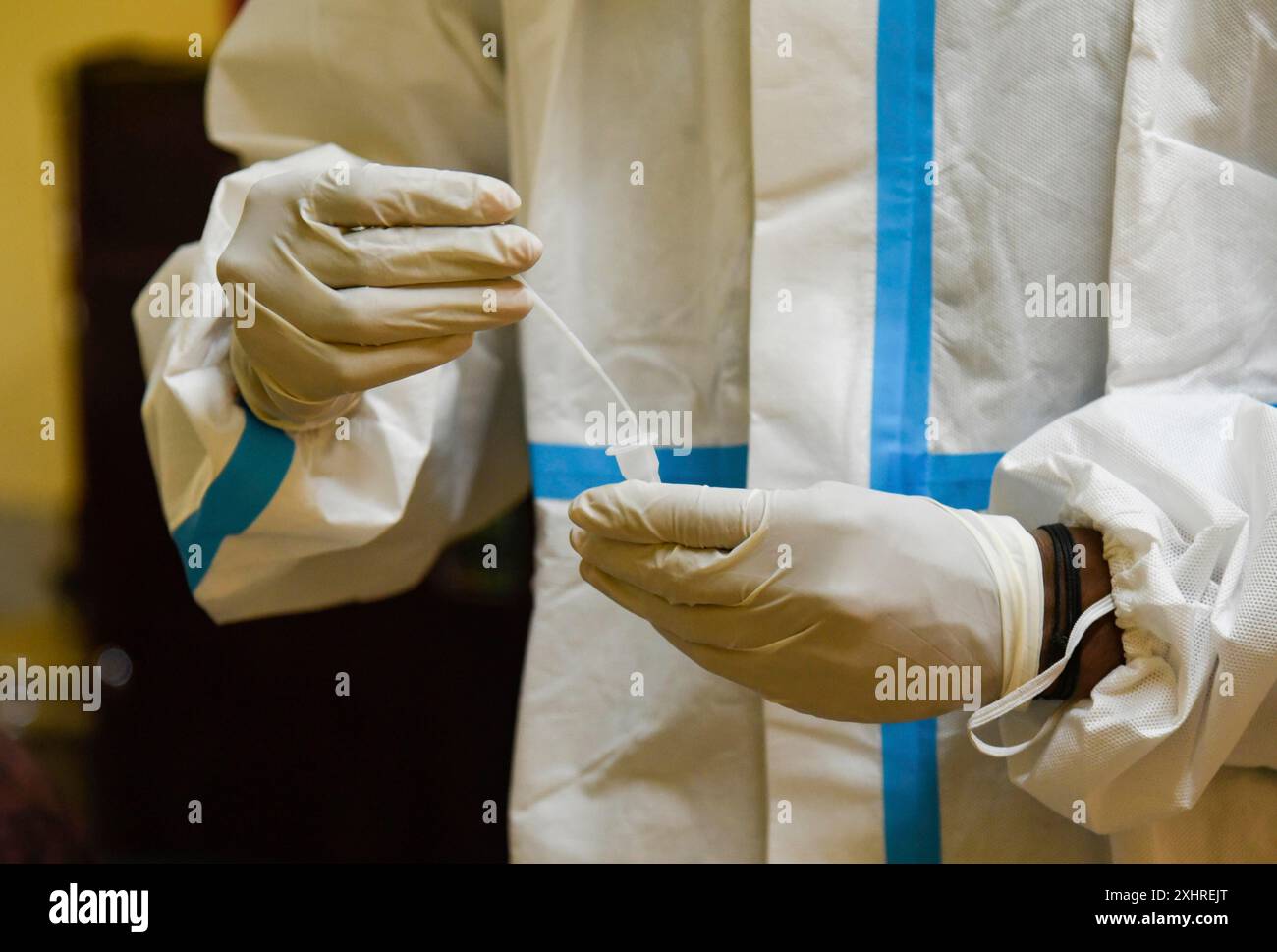 Health worker in personal protective equipment (PPE) collects a nasal ...