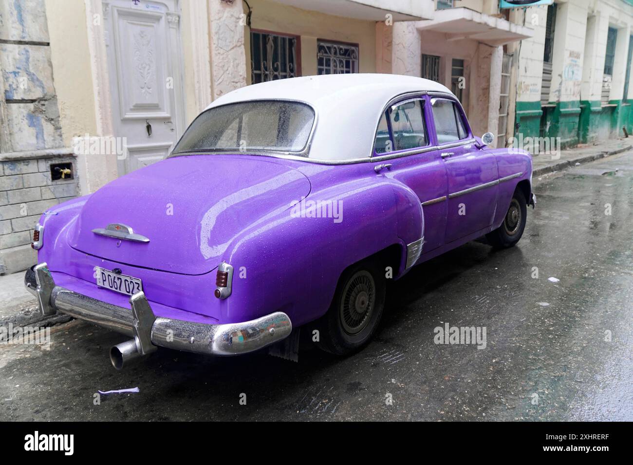 Havana, Cuba, Central America, Purple vintage car parked on wet street ...