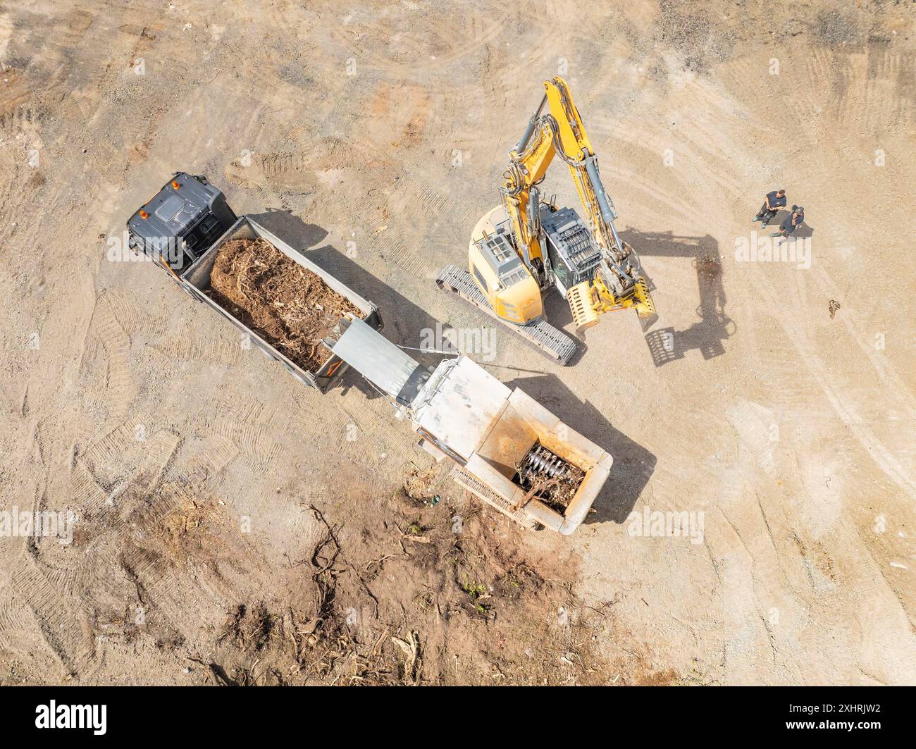 Aerial view of excavator and lorry working on a large construction site ...