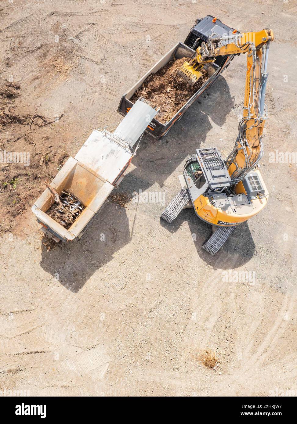 Aerial view of an excavator and a lorry working on a large construction ...