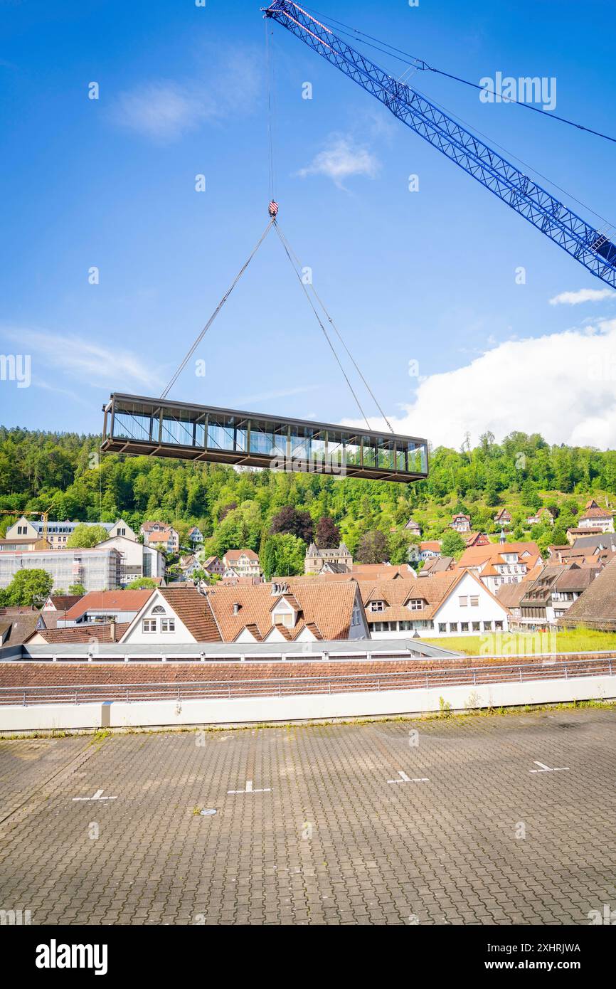 A crane lifts a large bridge in an urban area under a blue sky, bridge ...