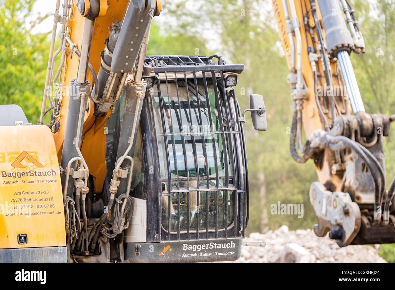 Large yellow excavator with grating in front of its cabin on a ...