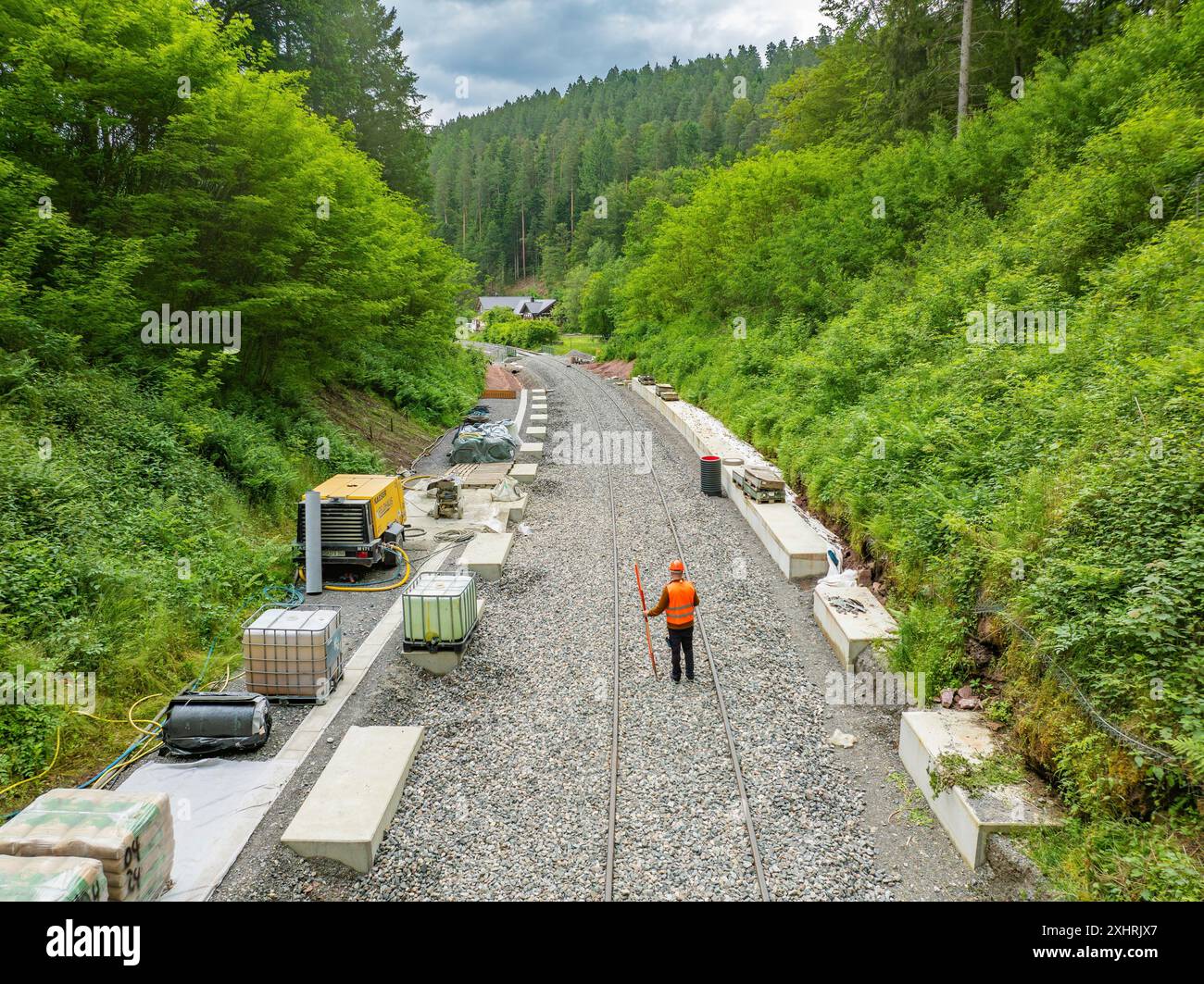 Workers working on the track in a green, wooded environment with ...