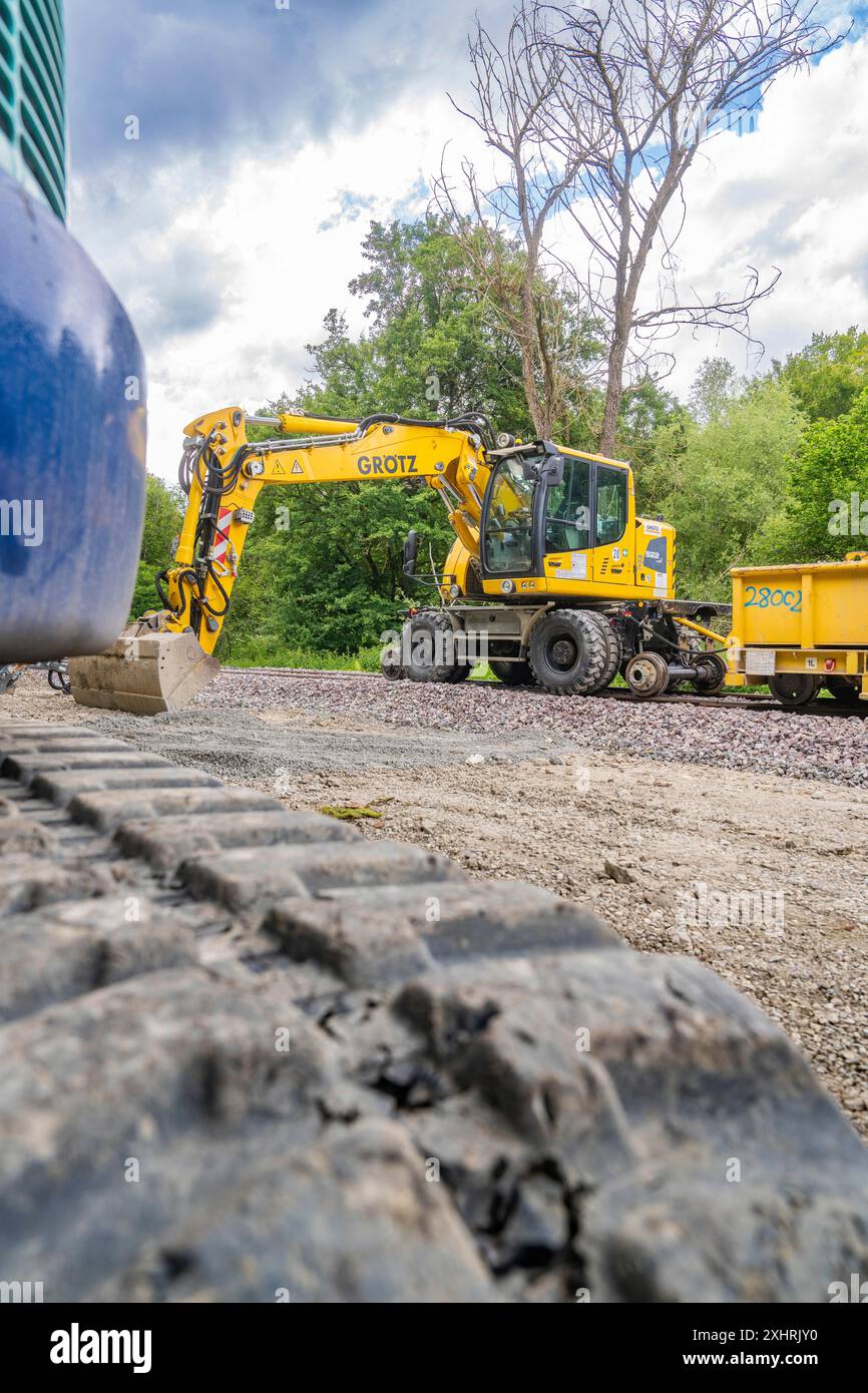 Yellow excavator on a construction site, the ground in focus, the sky ...