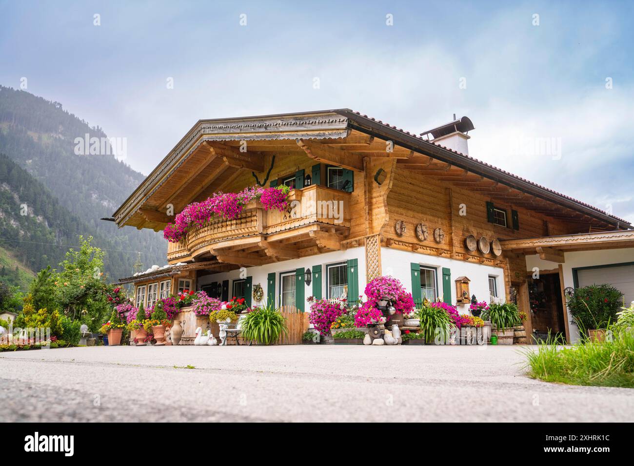 Traditional house in alpine area with richly decorated balcony and ...