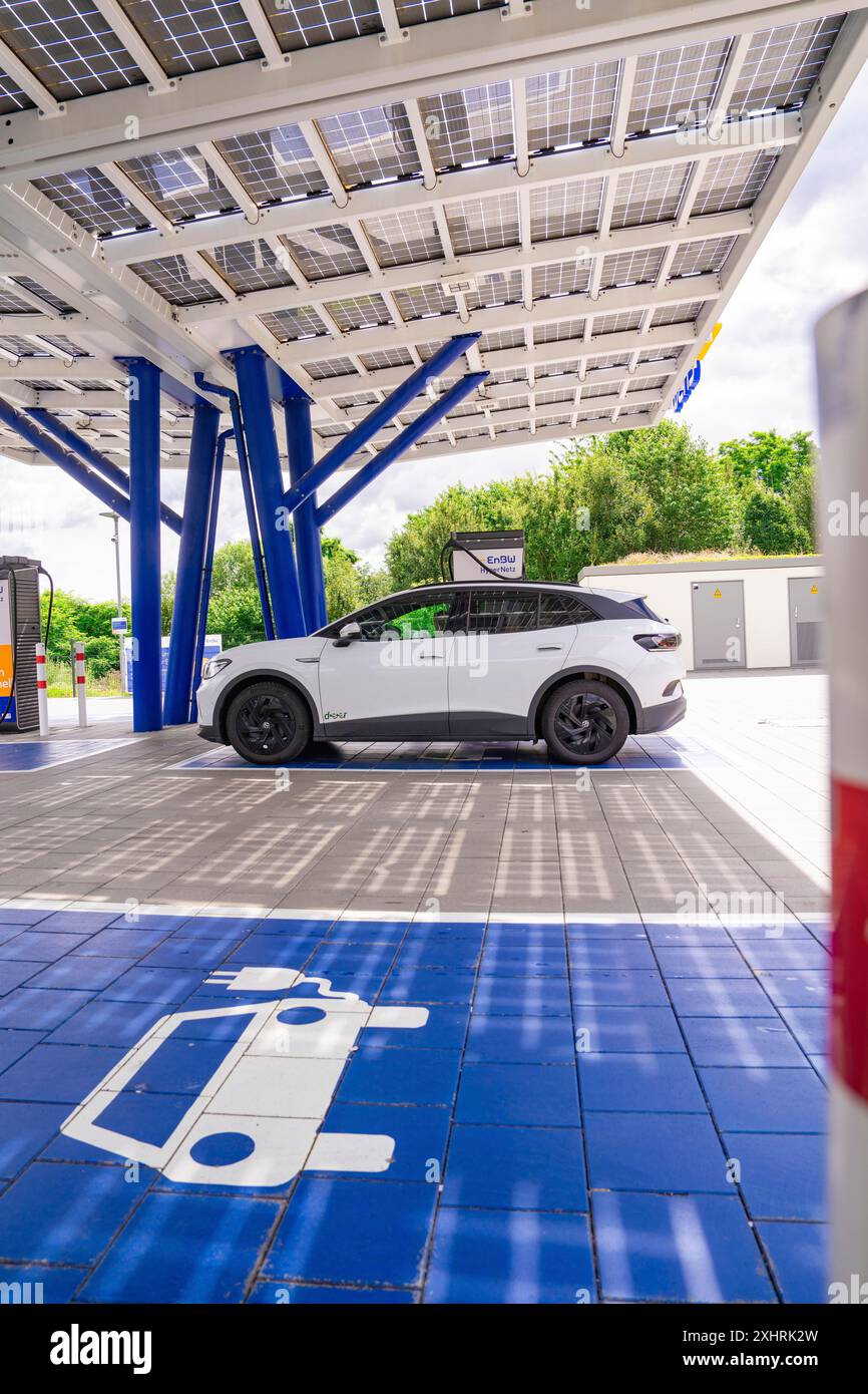 White electric car parked under a modern solar charging station ...