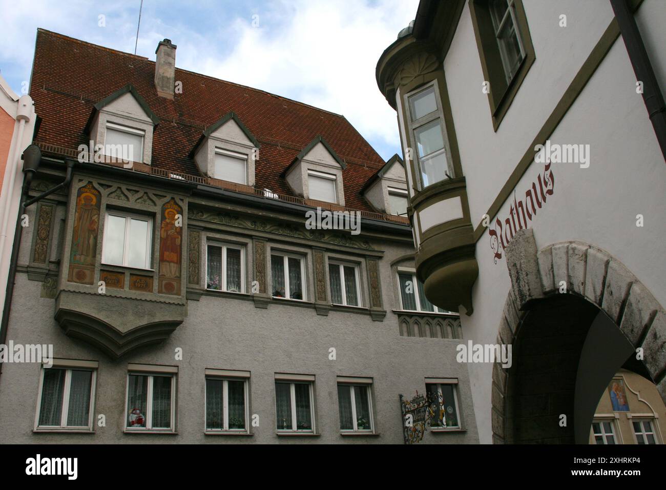 A classic Bavarian building with an archway under a blue sky with ...