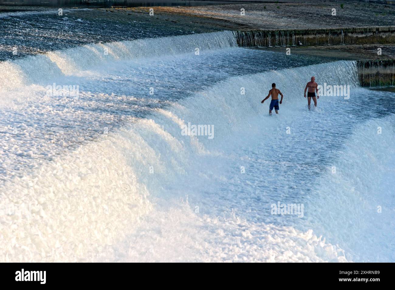 Men bathing in the spray of the cascades of the Lech weir, agitated ...