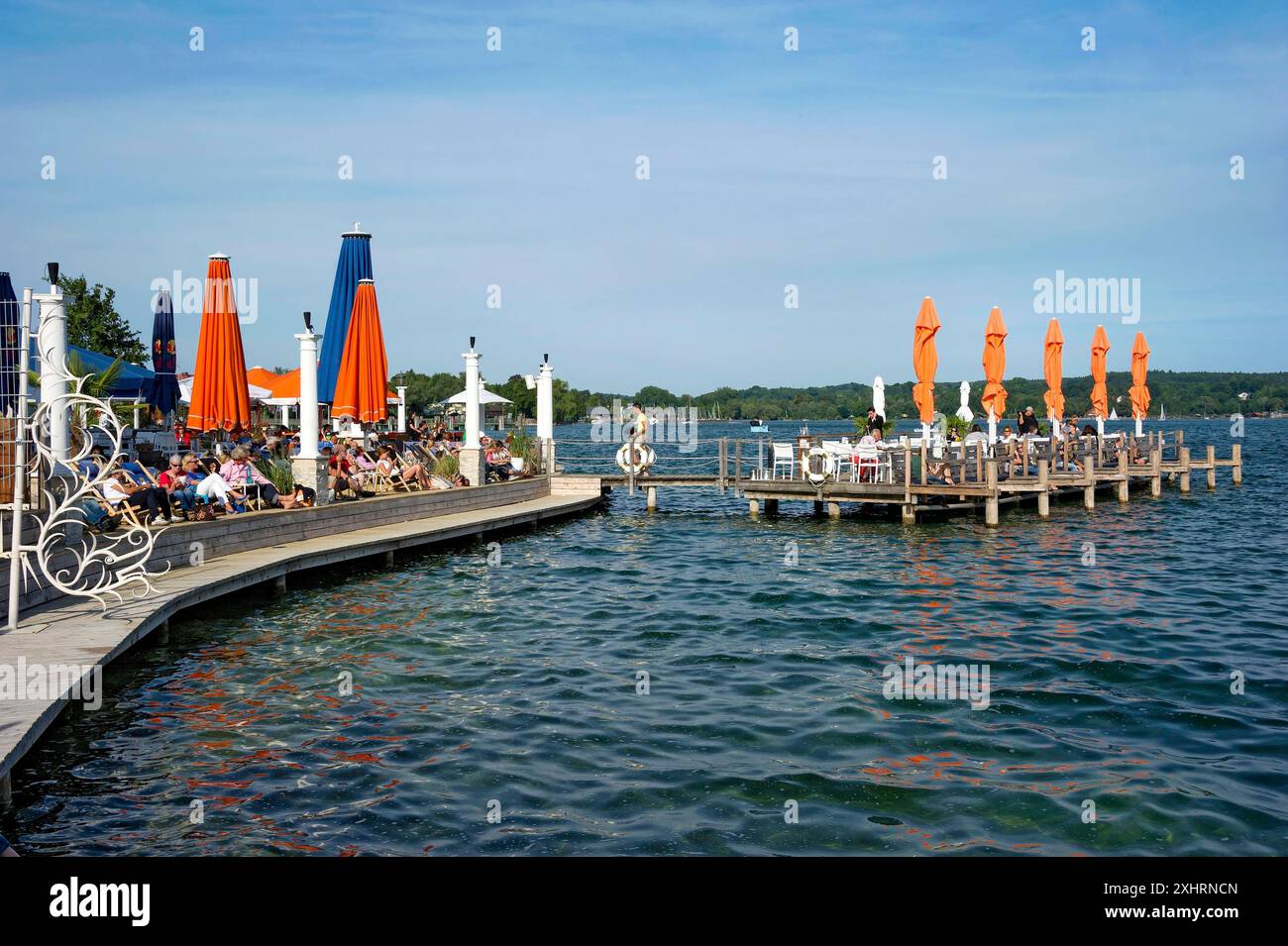 Sandy beach beach with deckchairs and jetties with dining tables ...