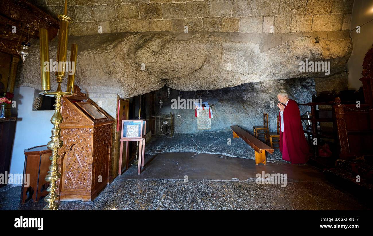 Praying woman in a sacred space with rock walls and an altar, rock ...