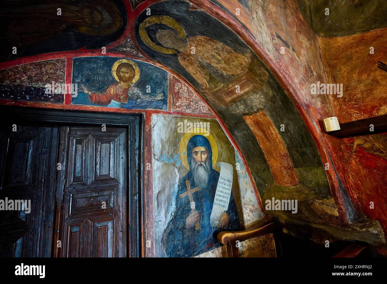 Scene of an orthodox church with religious wall paintings and a wooden ...
