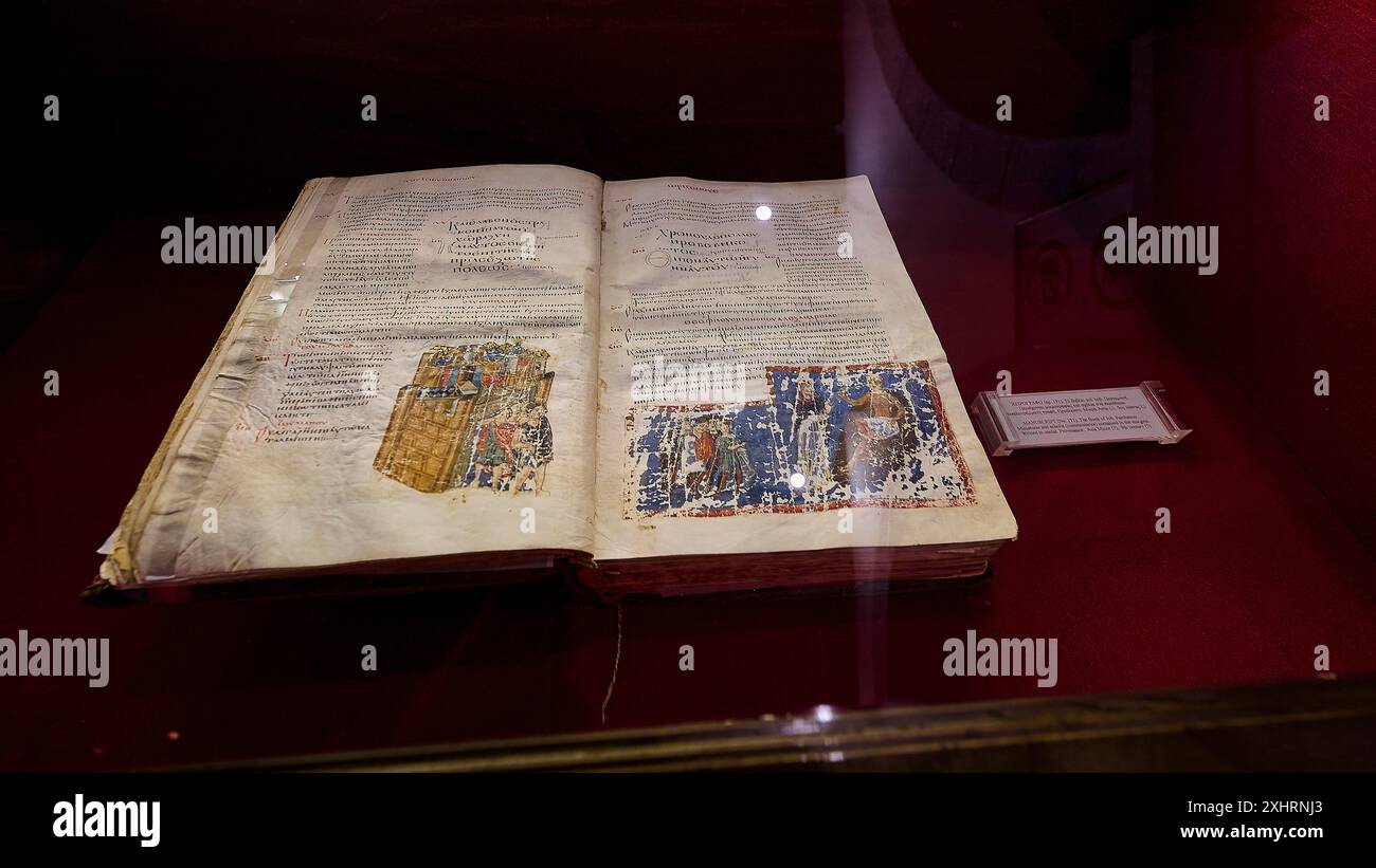 Antique religious manuscript in a glass case. Book pages with miniature ...