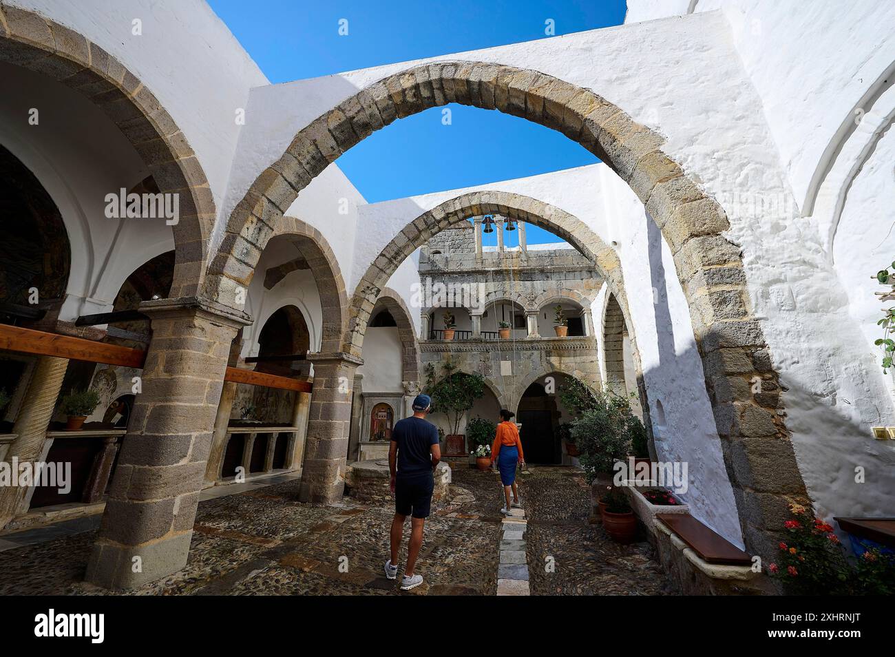 Historic monastery courtyard with stone arcades and bright white walls ...