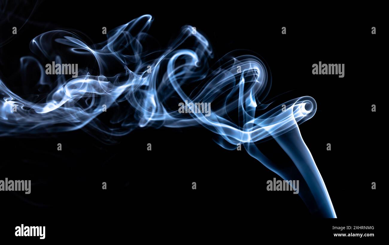 An abstract smoke art on a black background with intricate swirling ...