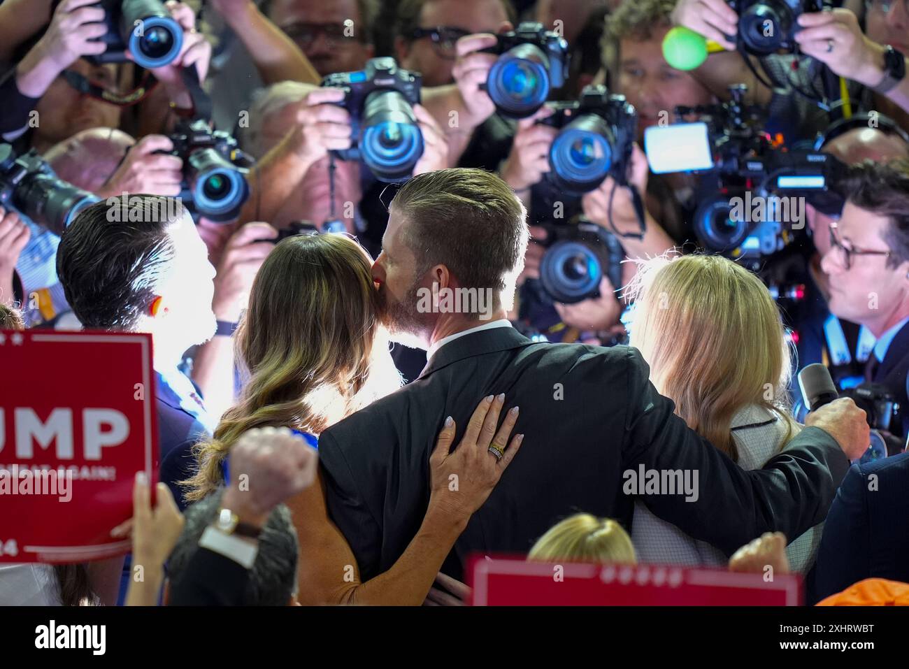 Eric Trump, center, kisses his wife, Lara Trump, left, as he hugs ...