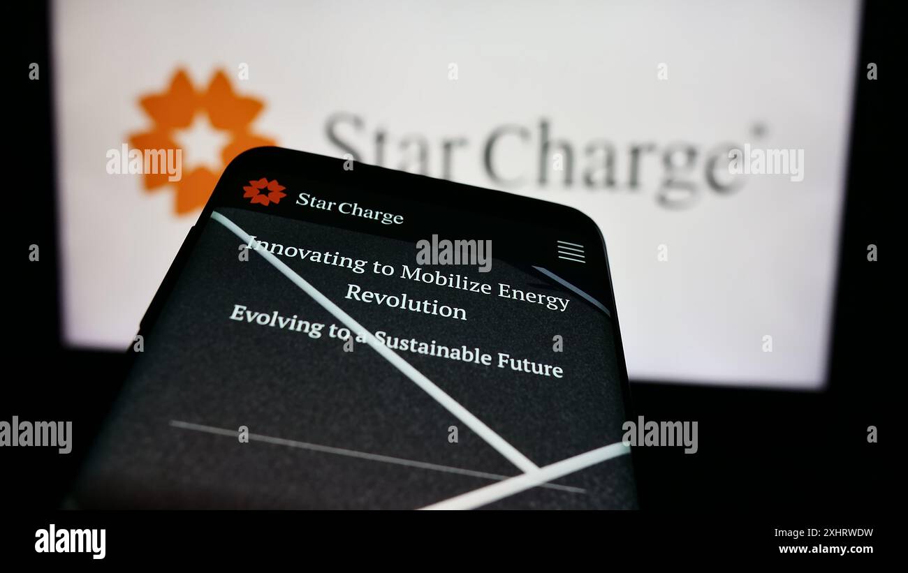 Mobile phone with website of Singaporean electric vehicle charging company Star Charge in front ...