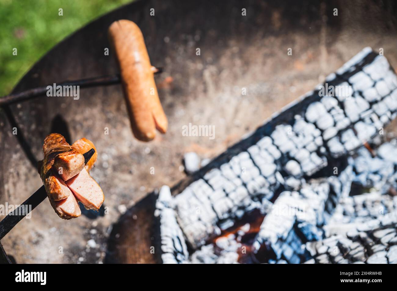 Barbecue on fire. Sausages heating above the campfire in Switzerland ...