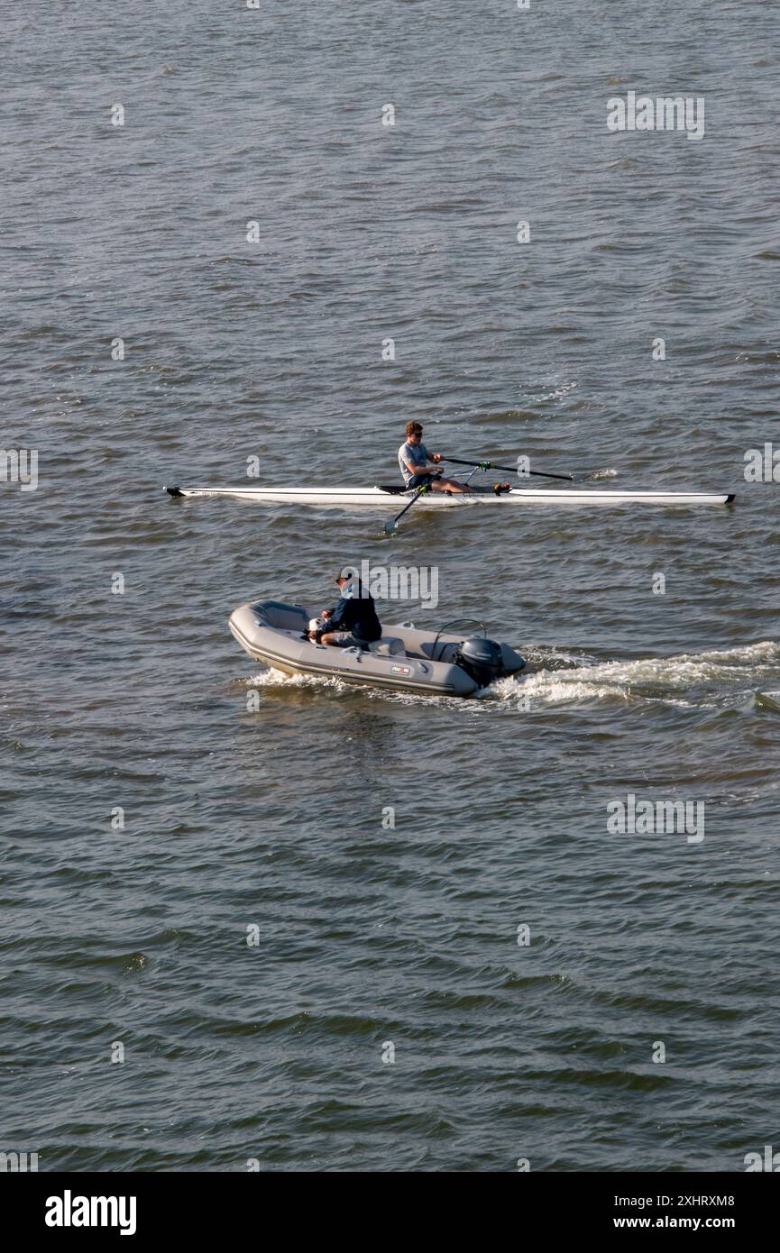 man rowing a single skull boat with an attendant trainer in a small ...