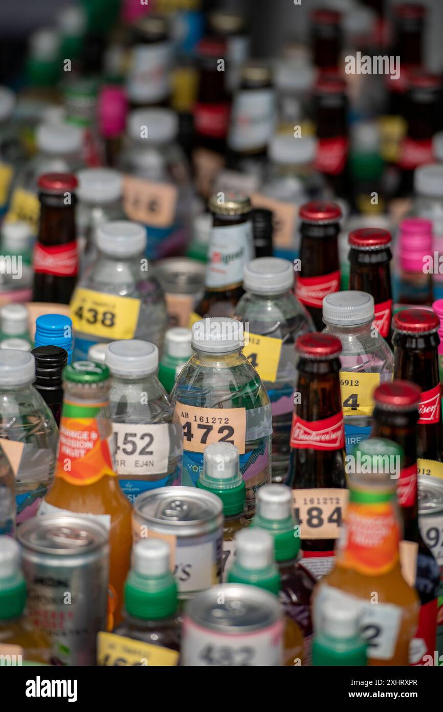 bottle prizes at a tombola stall with raffle ticket numbers taped to ...