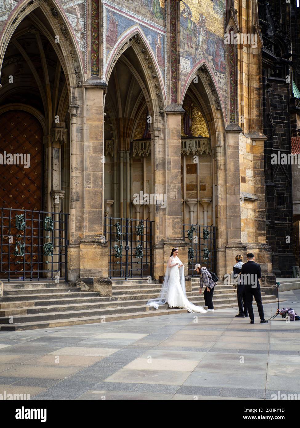 A bride poses for pre-wedding photo at the Prague Cathedral Golden Gate ...