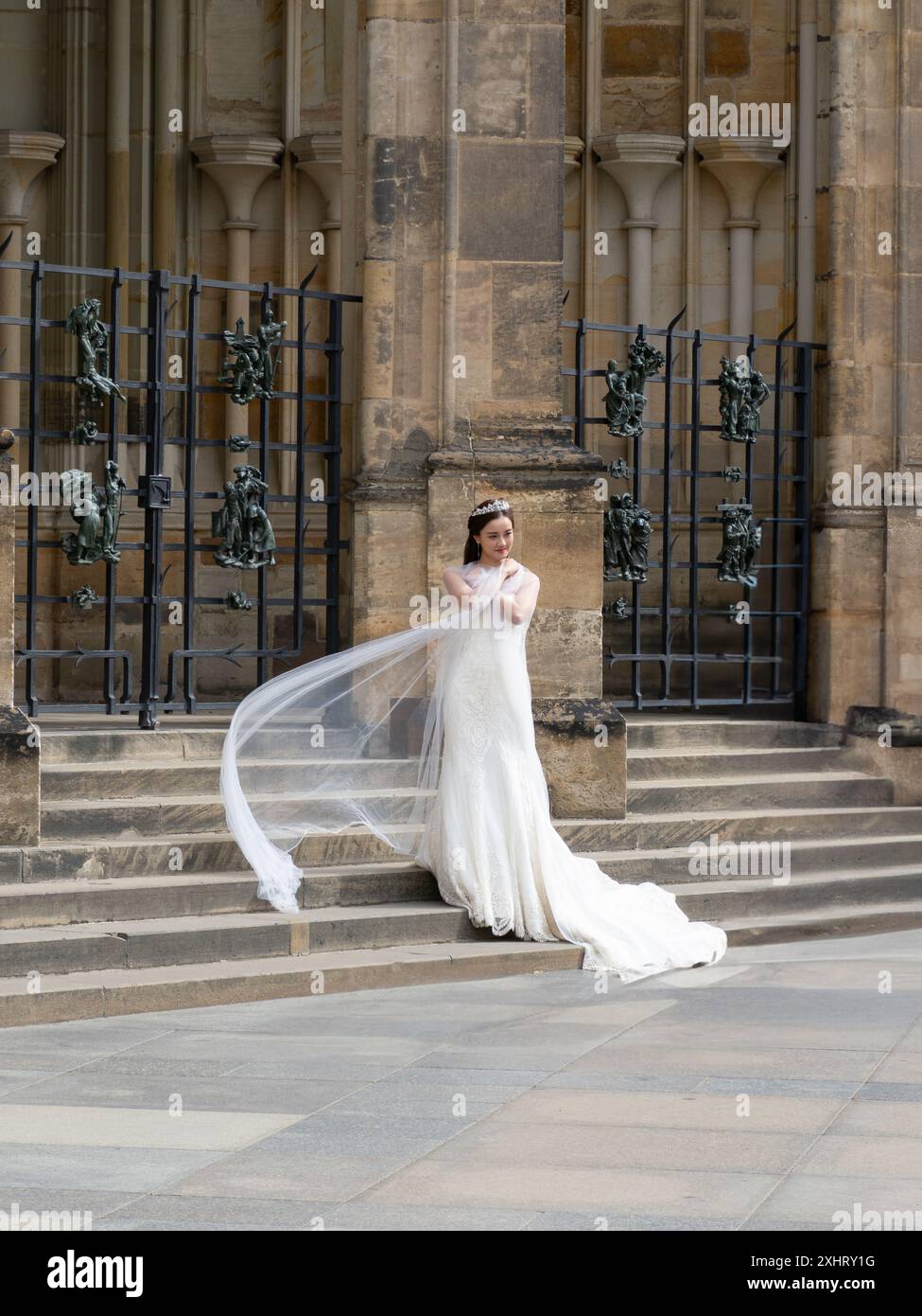 A bride poses for pre-wedding photo at the Prague Cathedral Golden Gate ...