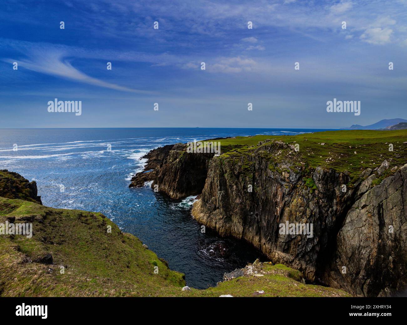 A distant old, rusting winch, on cliffs overlooking the Atlantic Ocean ...