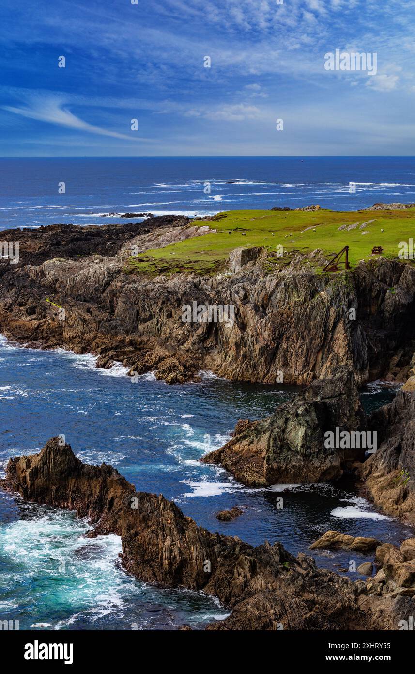 A distant old, rusting winch, on cliffs overlooking the Atlantic Ocean ...