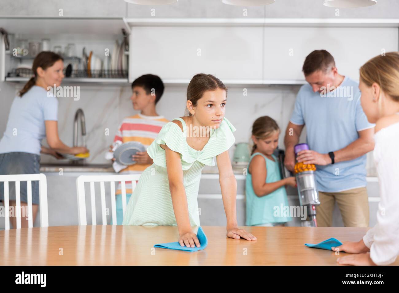 Teenage girls wash dining tables and help to do household chores ...
