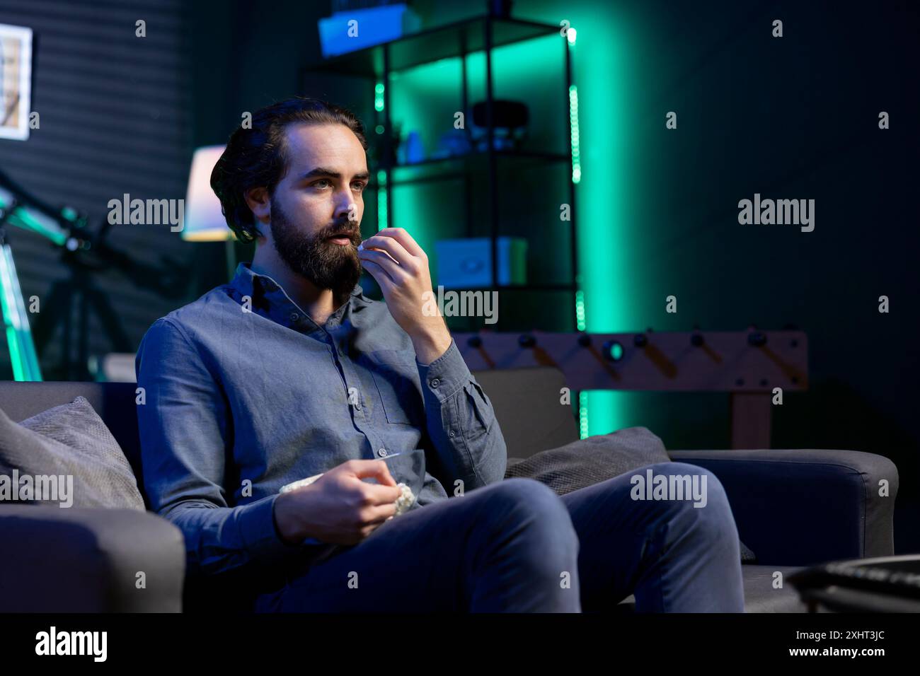 Man enjoying leisure time at home eating popcorn and watching TV ...