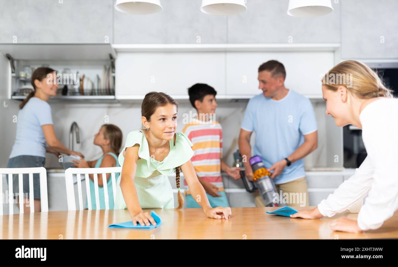 Teenage girls wash dining tables and help to do household chores ...