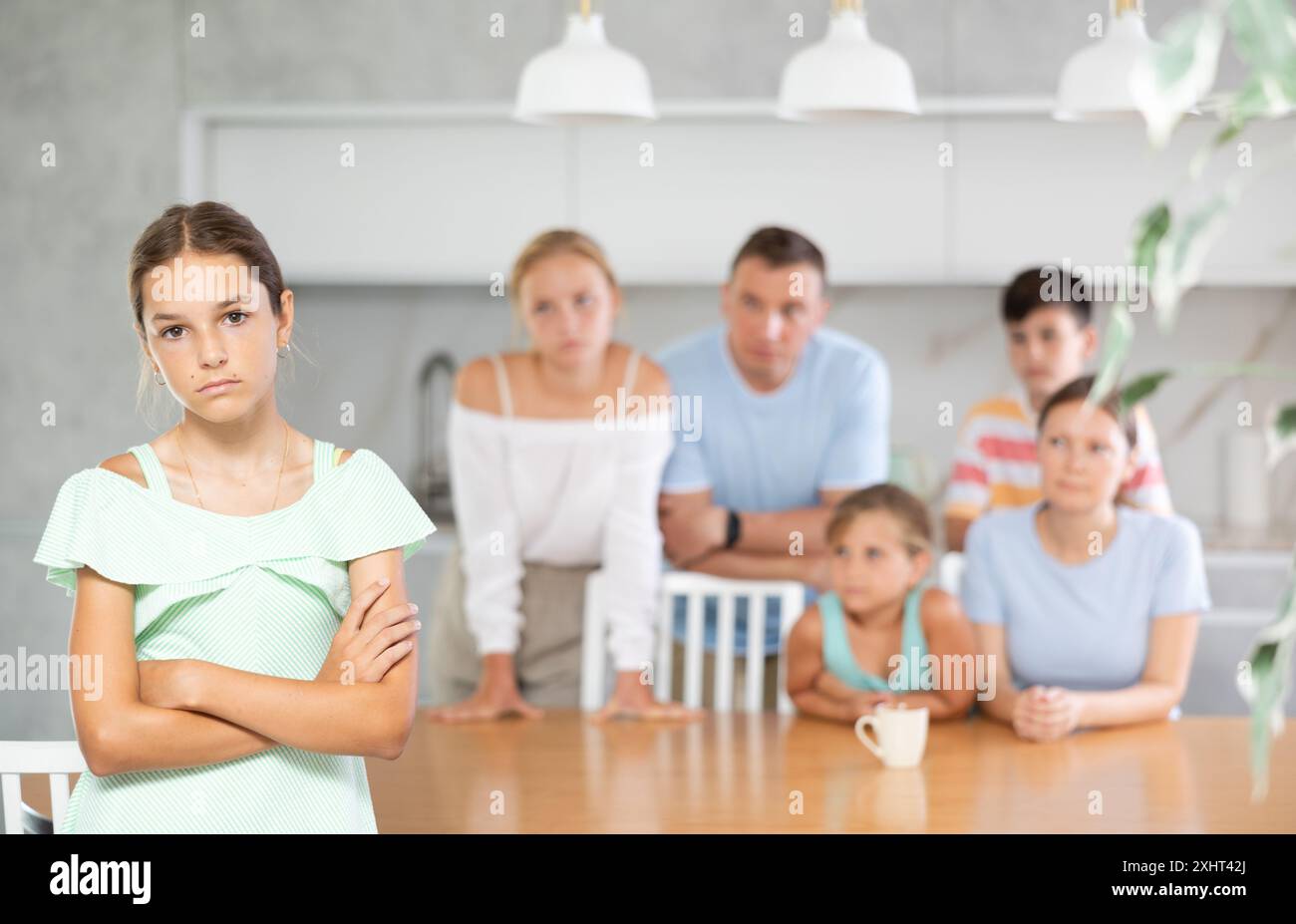 Angry female child turned away from parents and sisters and ignores ...