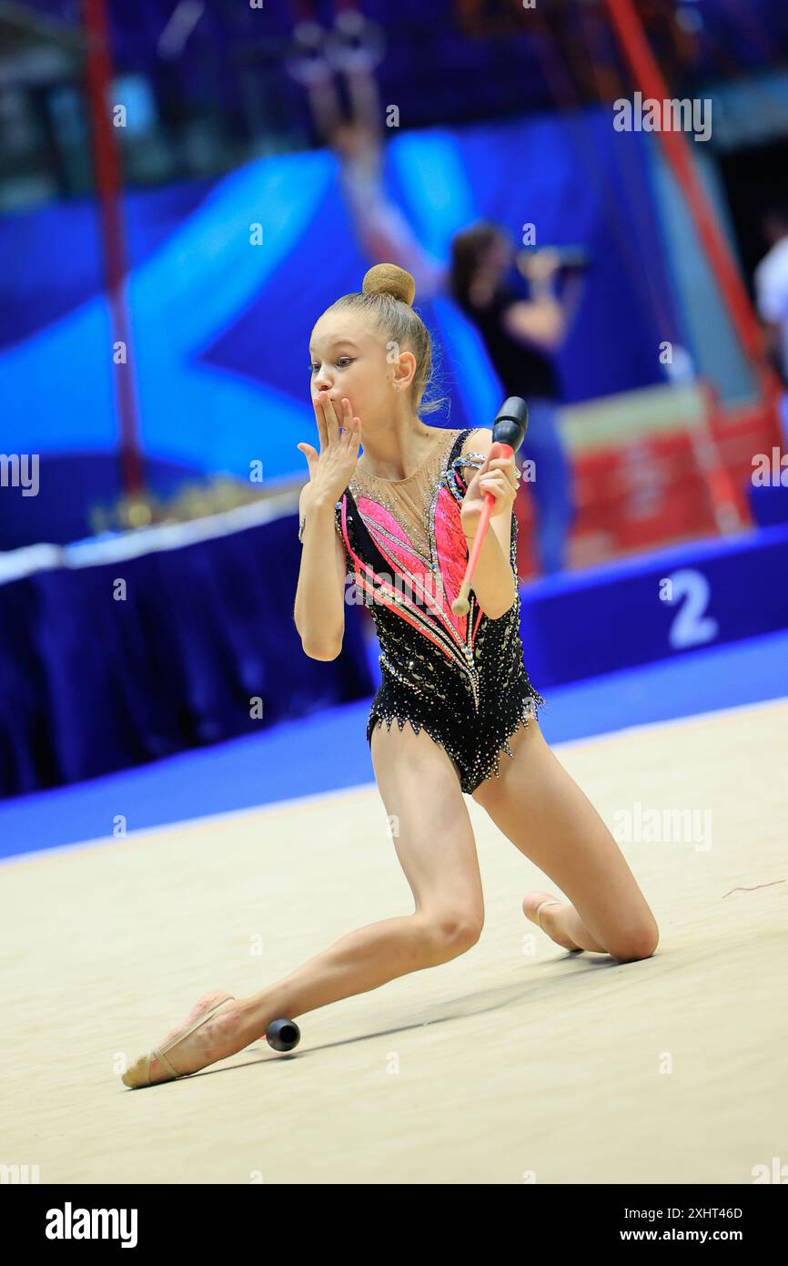 Rhythmic Gymnast demonstrates skill with clubs, showcasing agility ...