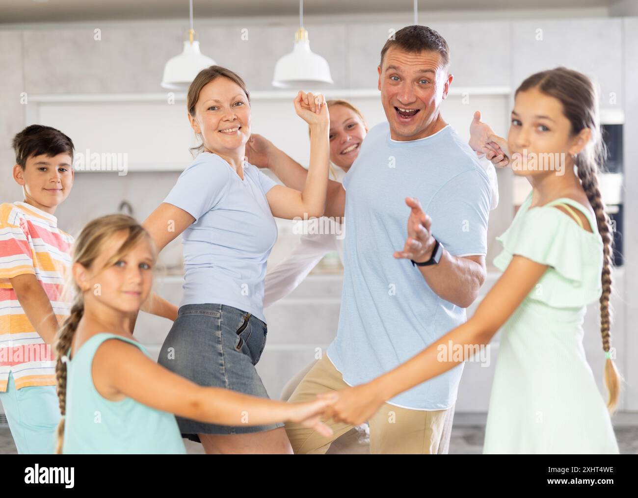 Children stand around their dancing parents in kitchen Stock Photo - Alamy