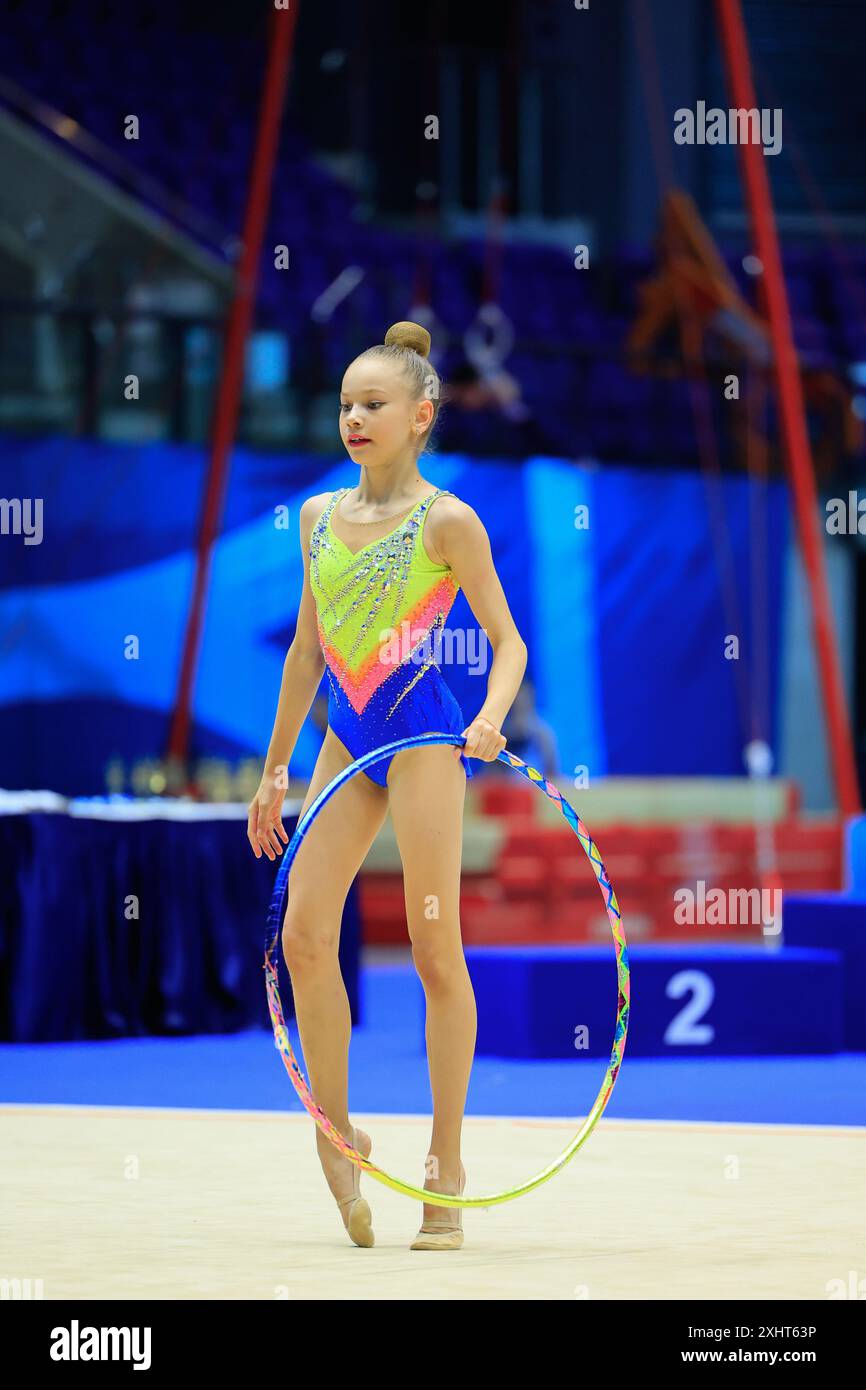 Female gymnast demonstrates agility and artistry with hula hoop in ...