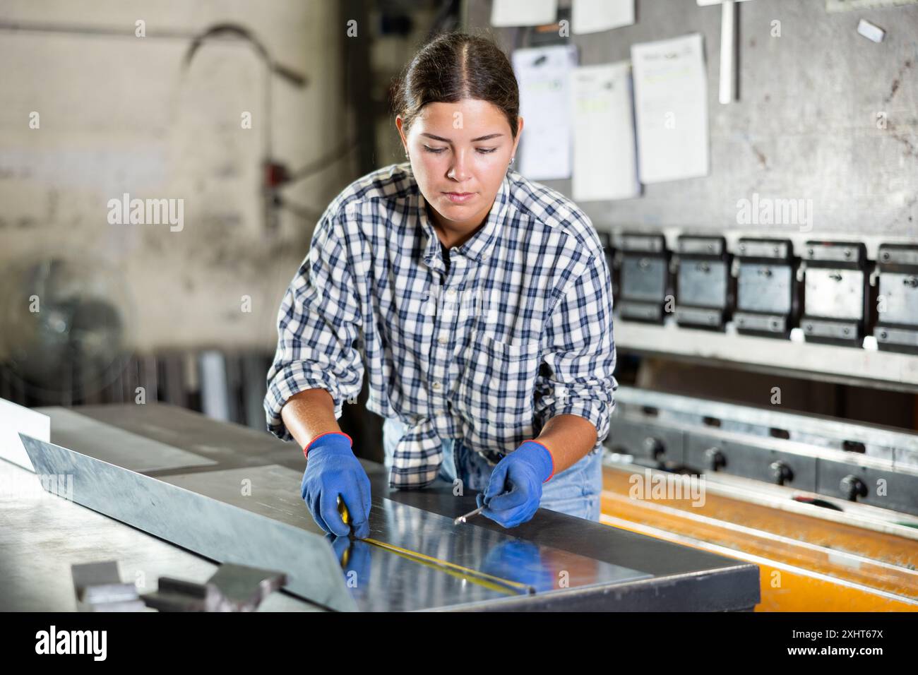 Woman measuring sheet of metal with tape measure Stock Photo - Alamy