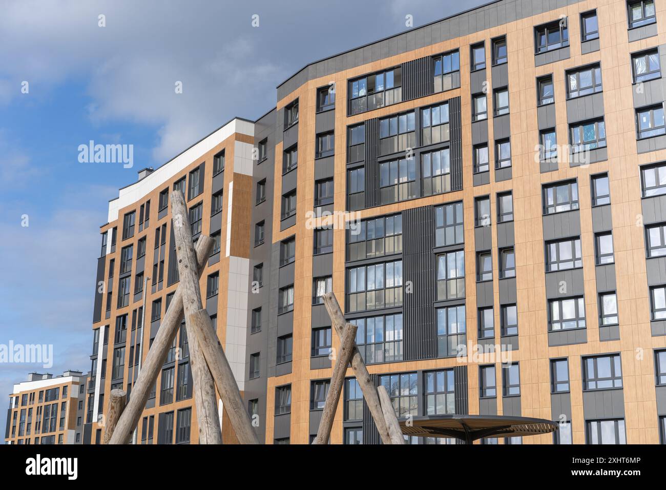 Modern brown building facade with shiny mirror windows against blue sky ...